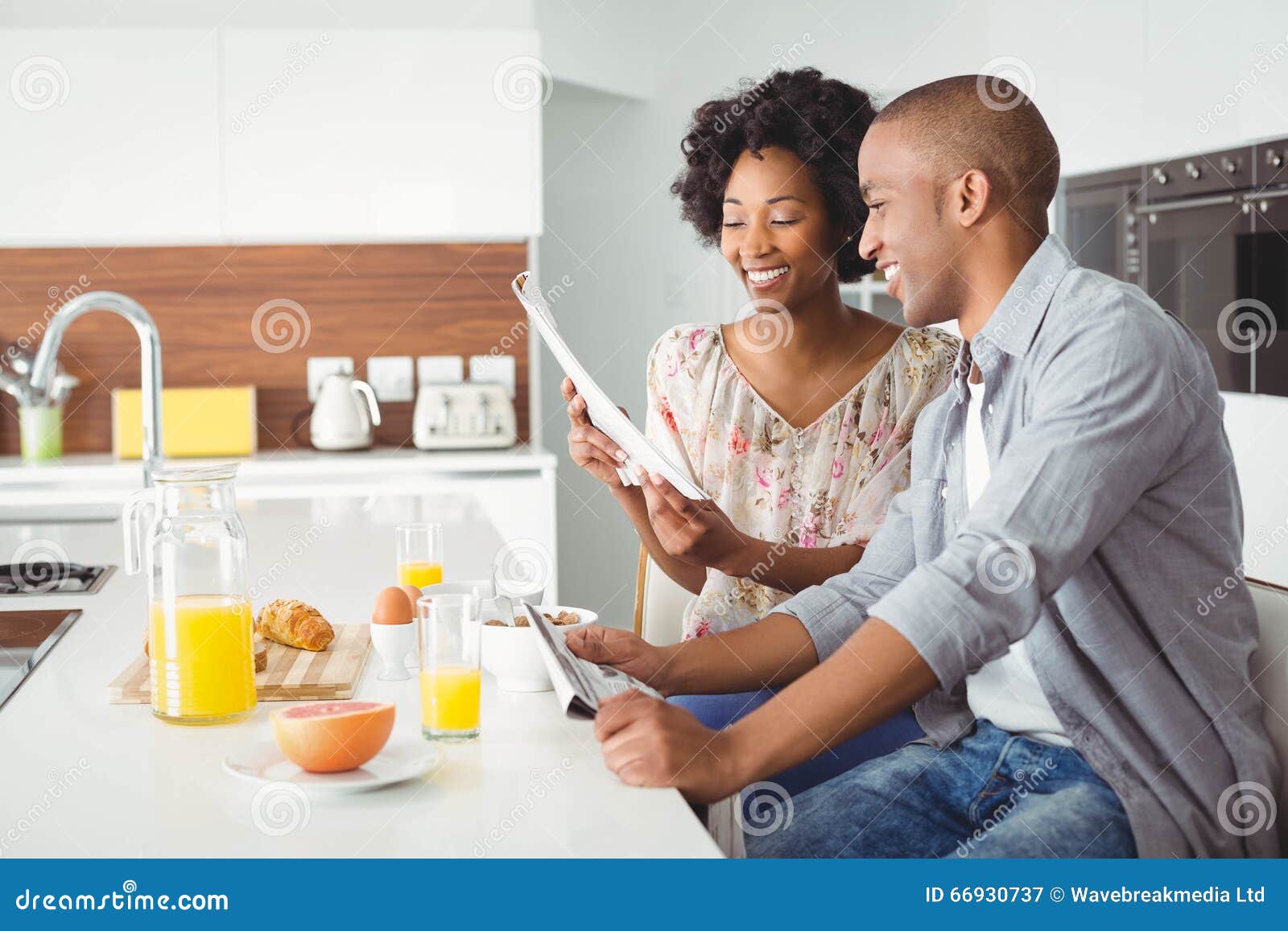 Smiling Couple Reading and Eating Breakfast Together Stock Image ...