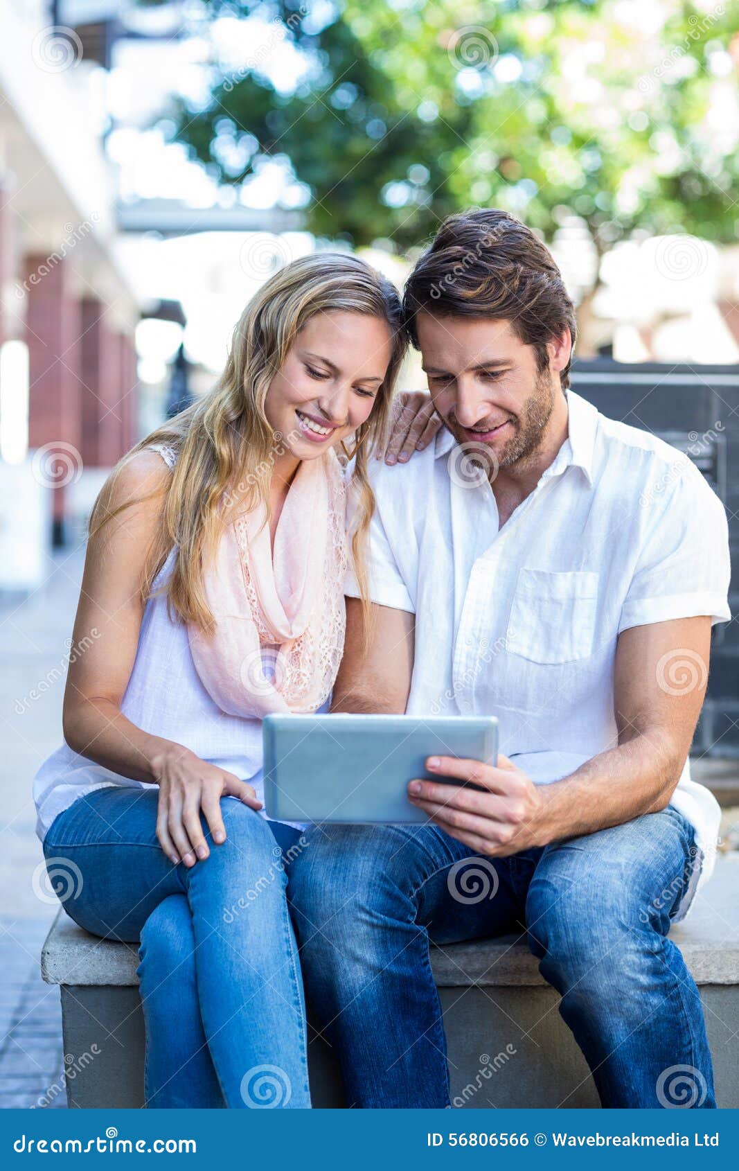 Smiling Couple Sitting and Using Tablet Computer Together Stock Photo ...