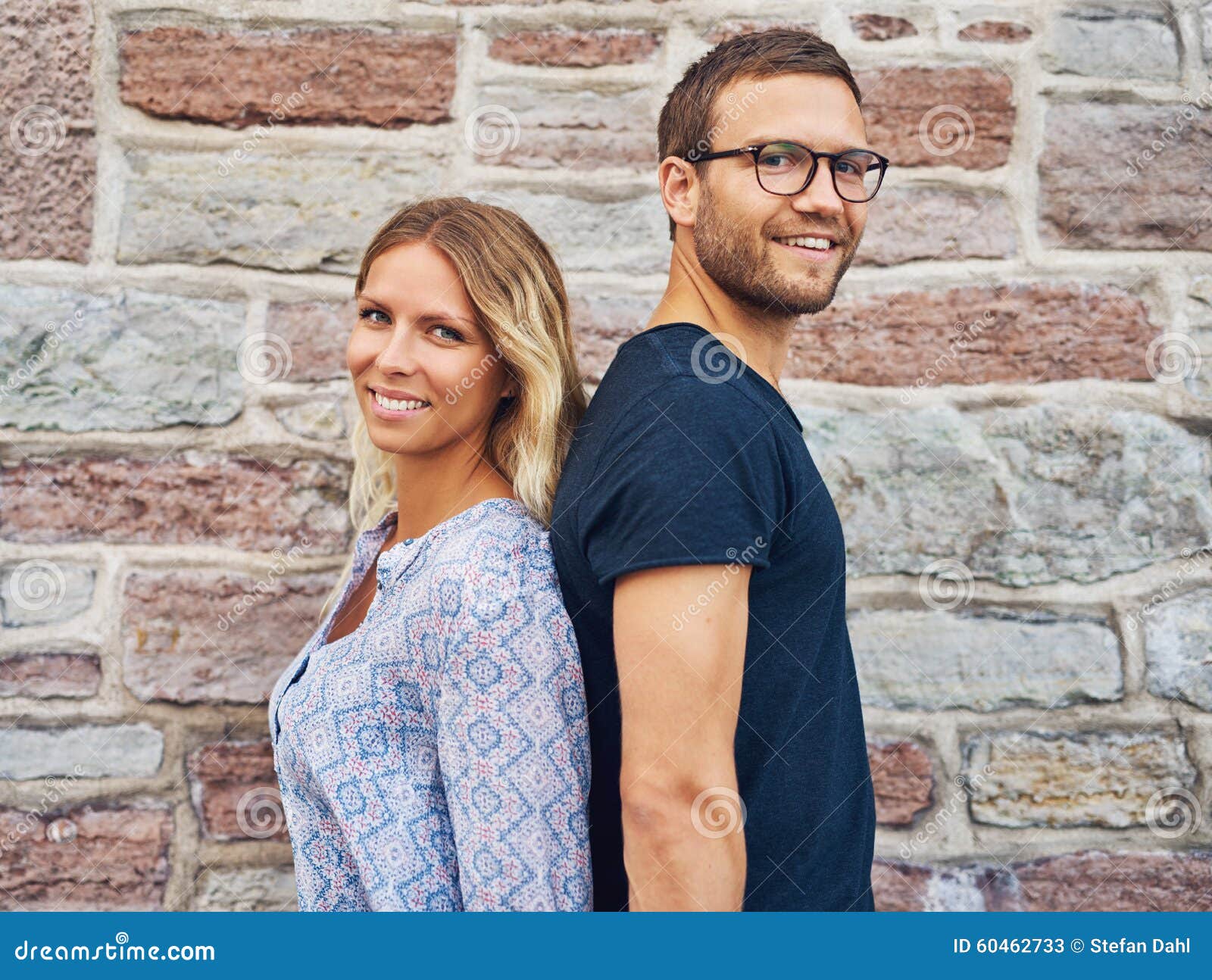 Smiling Couple Standing Back To Back Against Wall Stock Image - Image ...