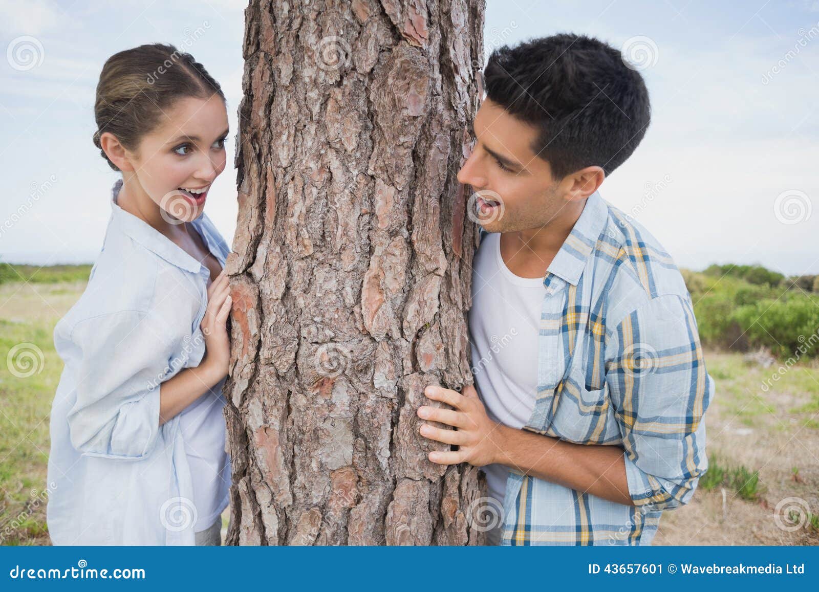 Smiling Couple Standing by Tree Trunk Stock Image - Image of standing ...