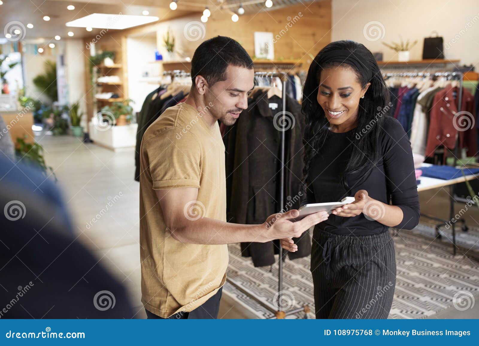 Smiling Couple Using Tablet Computer in a Clothes Shop Stock Photo ...