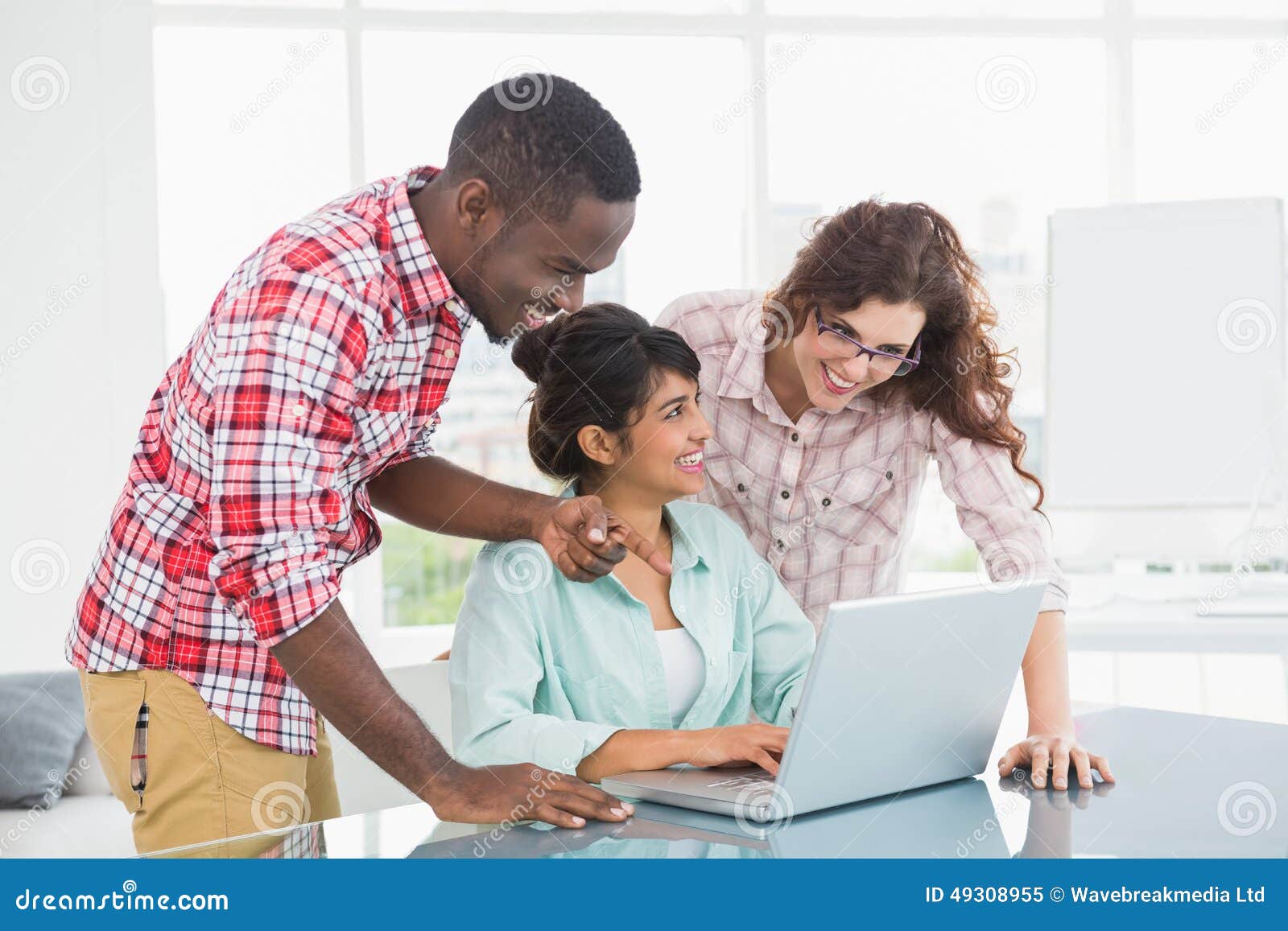 Smiling Coworkers Interacting and Using Laptop Stock Image - Image of ...