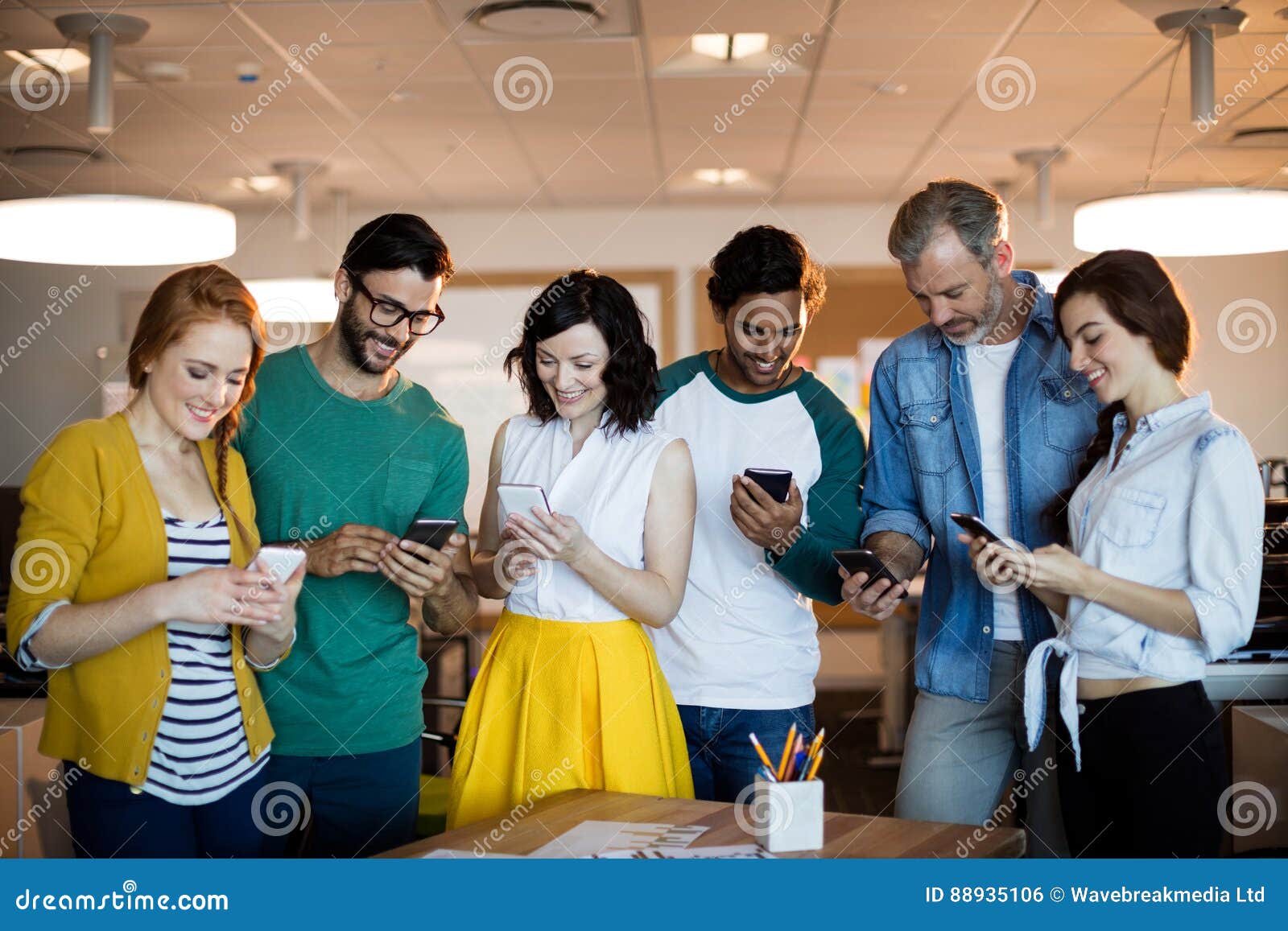 Smiling Creative Business Team Using Mobile Phone Stock Photo - Image ...
