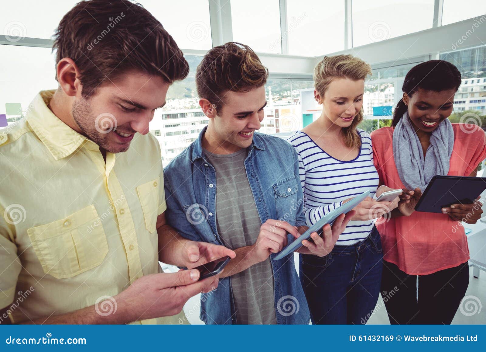 Smiling Creative Team Standing in a Line Using Technology Stock Image ...