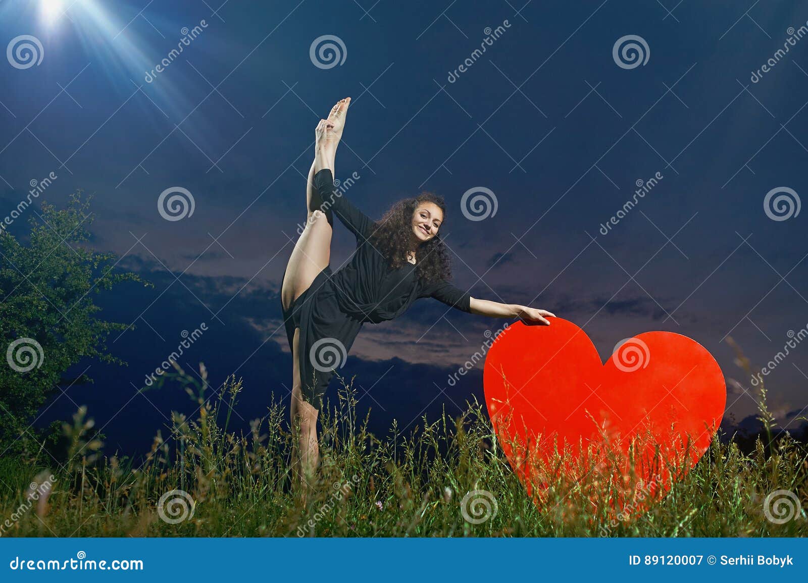 Smiling, Curly Dancer Performs Vertical Side Splits in Grassy Field ...