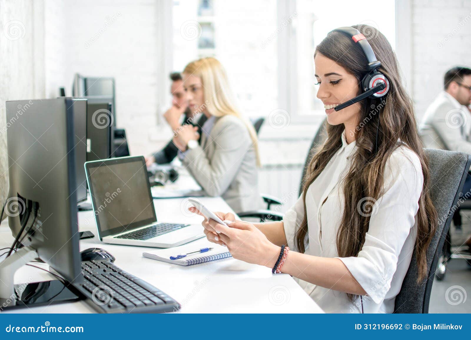 Smiling Customer Support Agent with Headset Using Smart Phone in Call ...