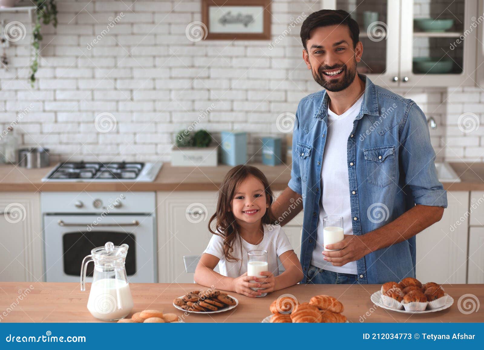 Smiling Daddy and Daughter with Glasses of Milk and Cookies on the ...