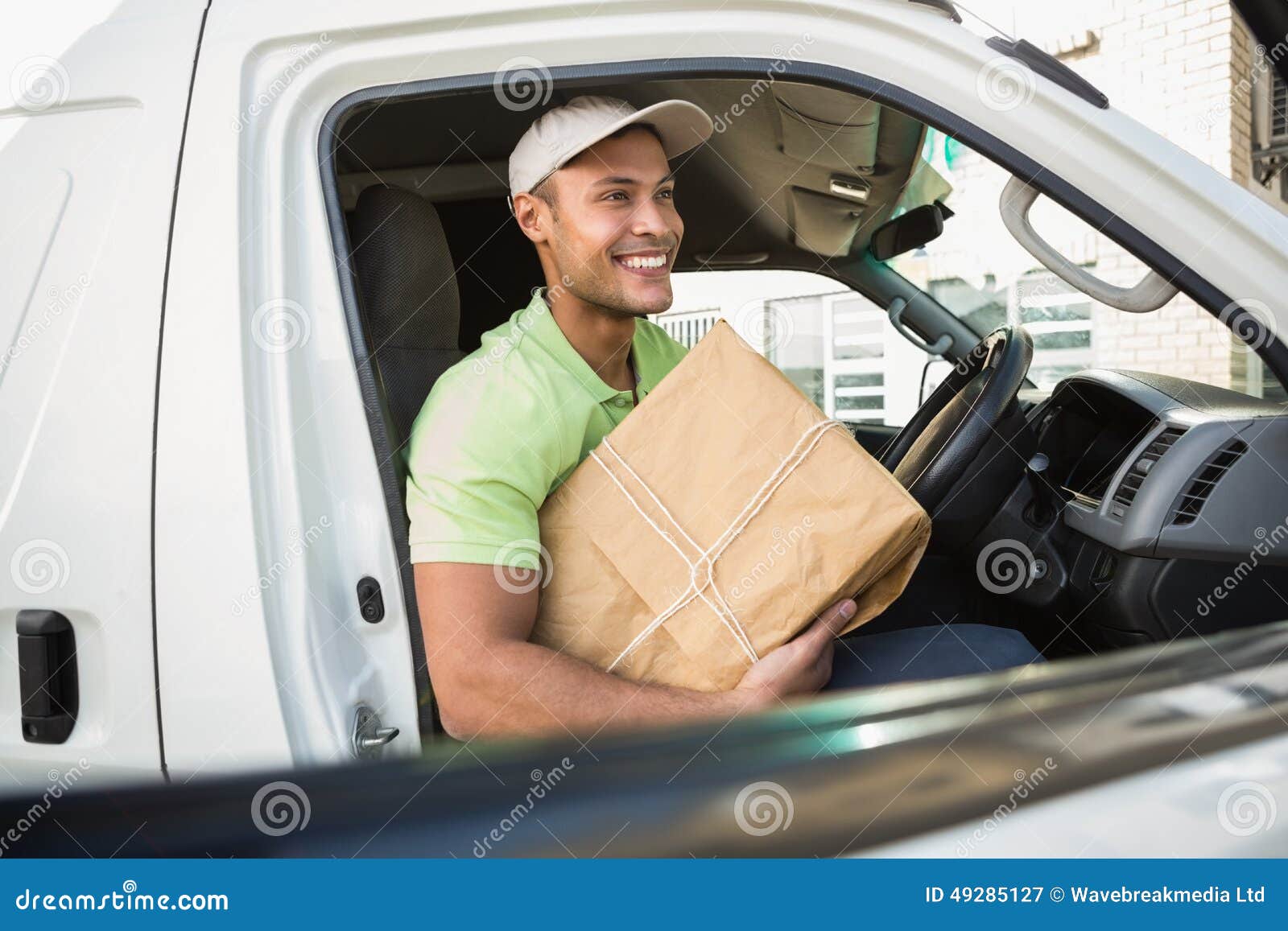 Smiling Delivery Driver in His Van Holding Parcel Stock Image - Image ...