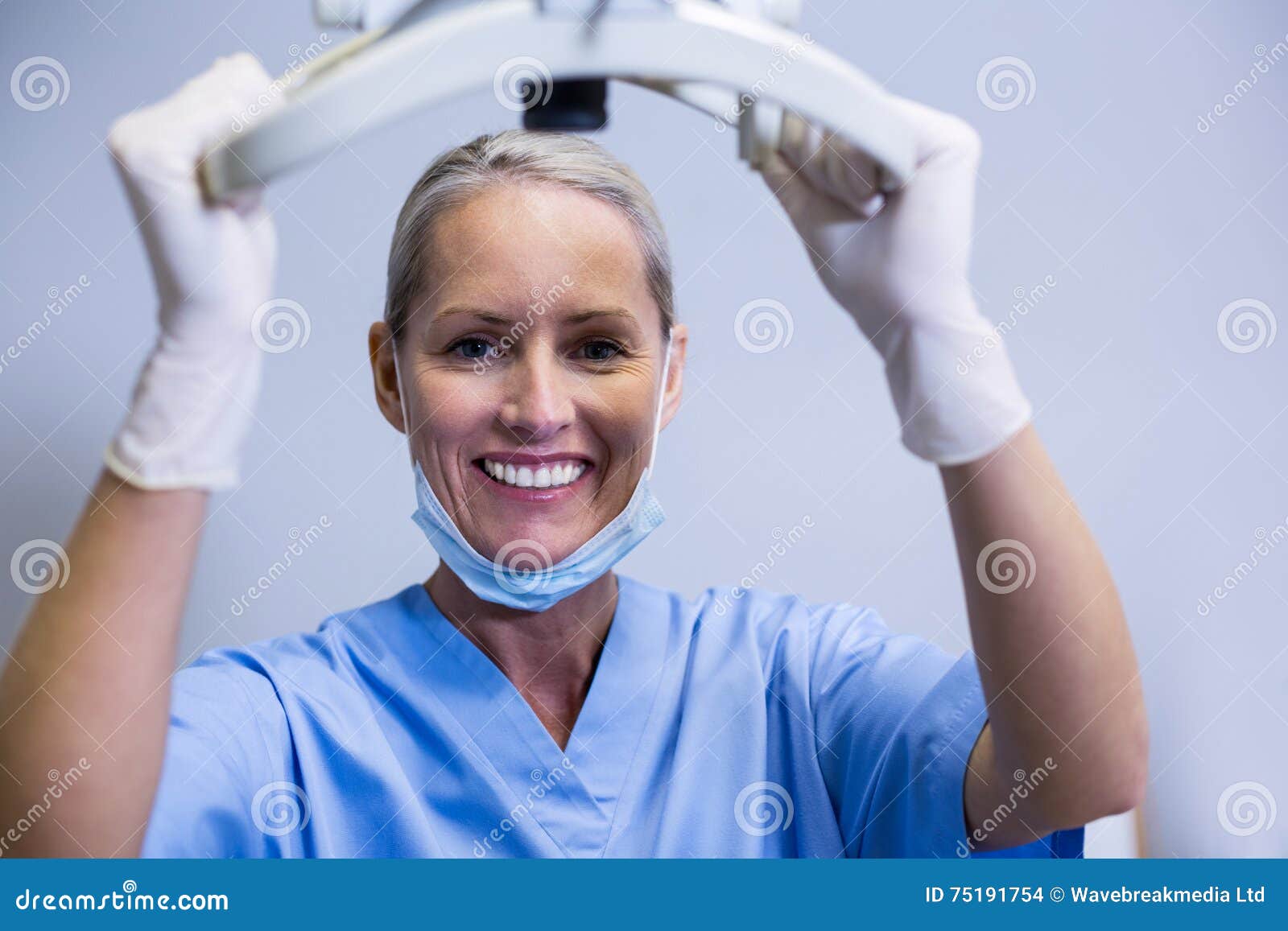 Smiling Dental Assistant Adjusting Light in Clinic Stock Photo - Image ...