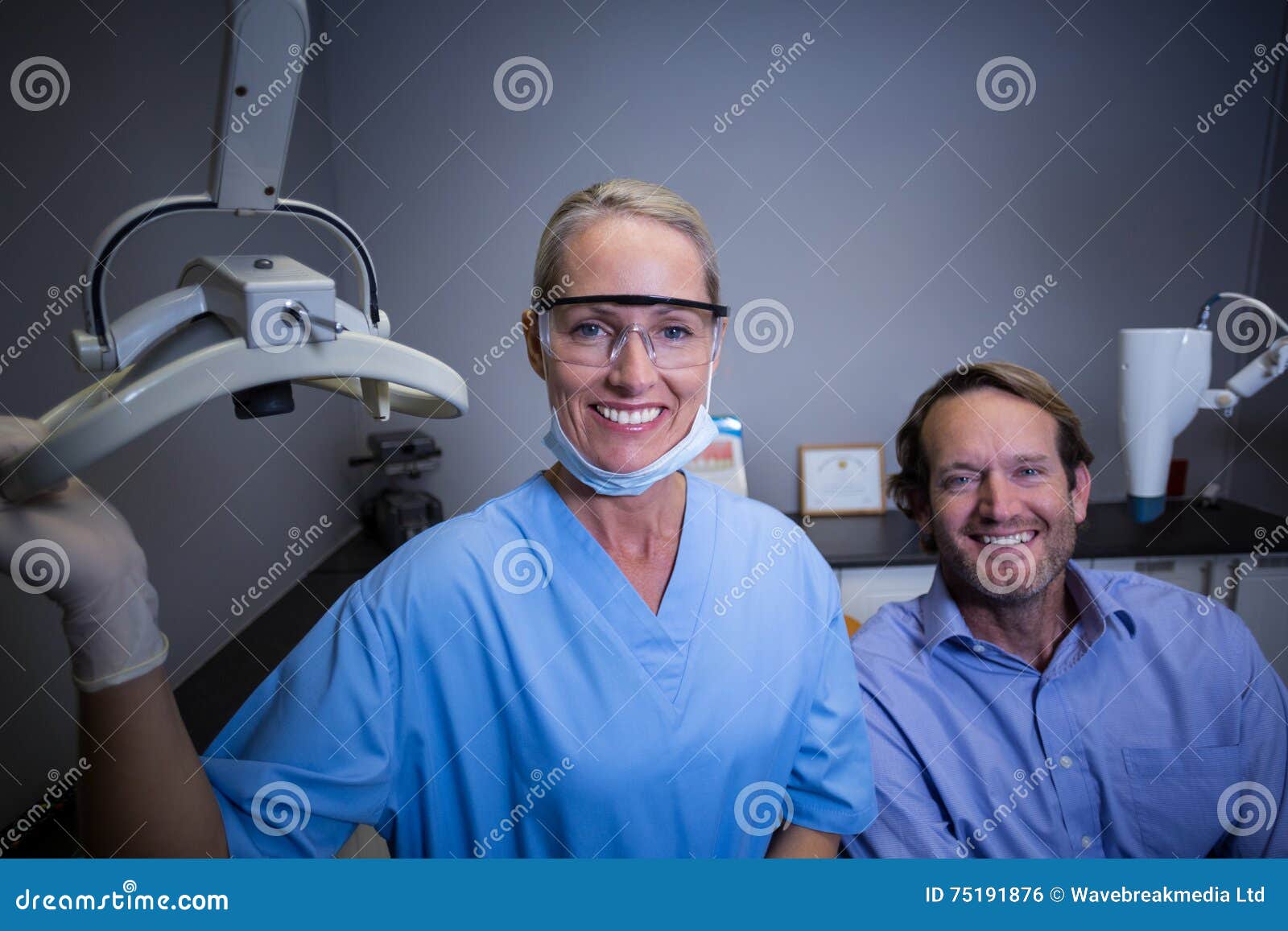 Smiling Dental Assistant Adjusting Light in Clinic Stock Photo - Image ...
