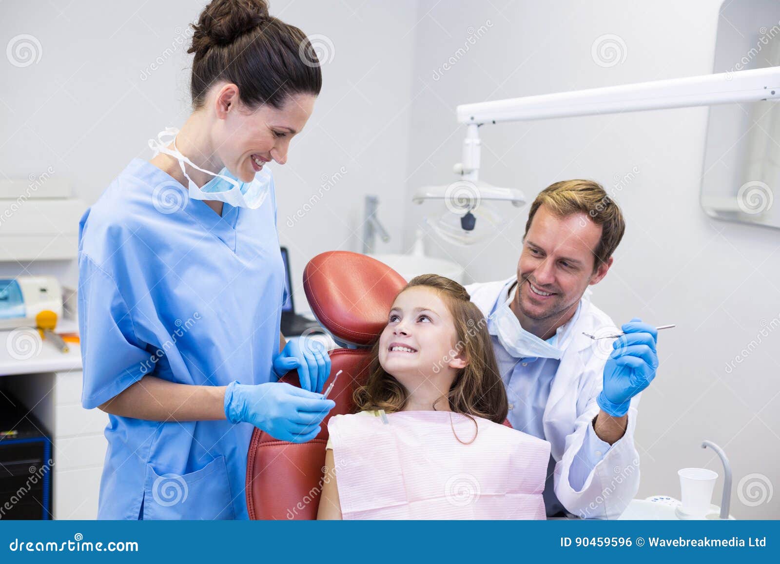 Smiling Dentists Interacting with Young Patient Stock Photo - Image of ...