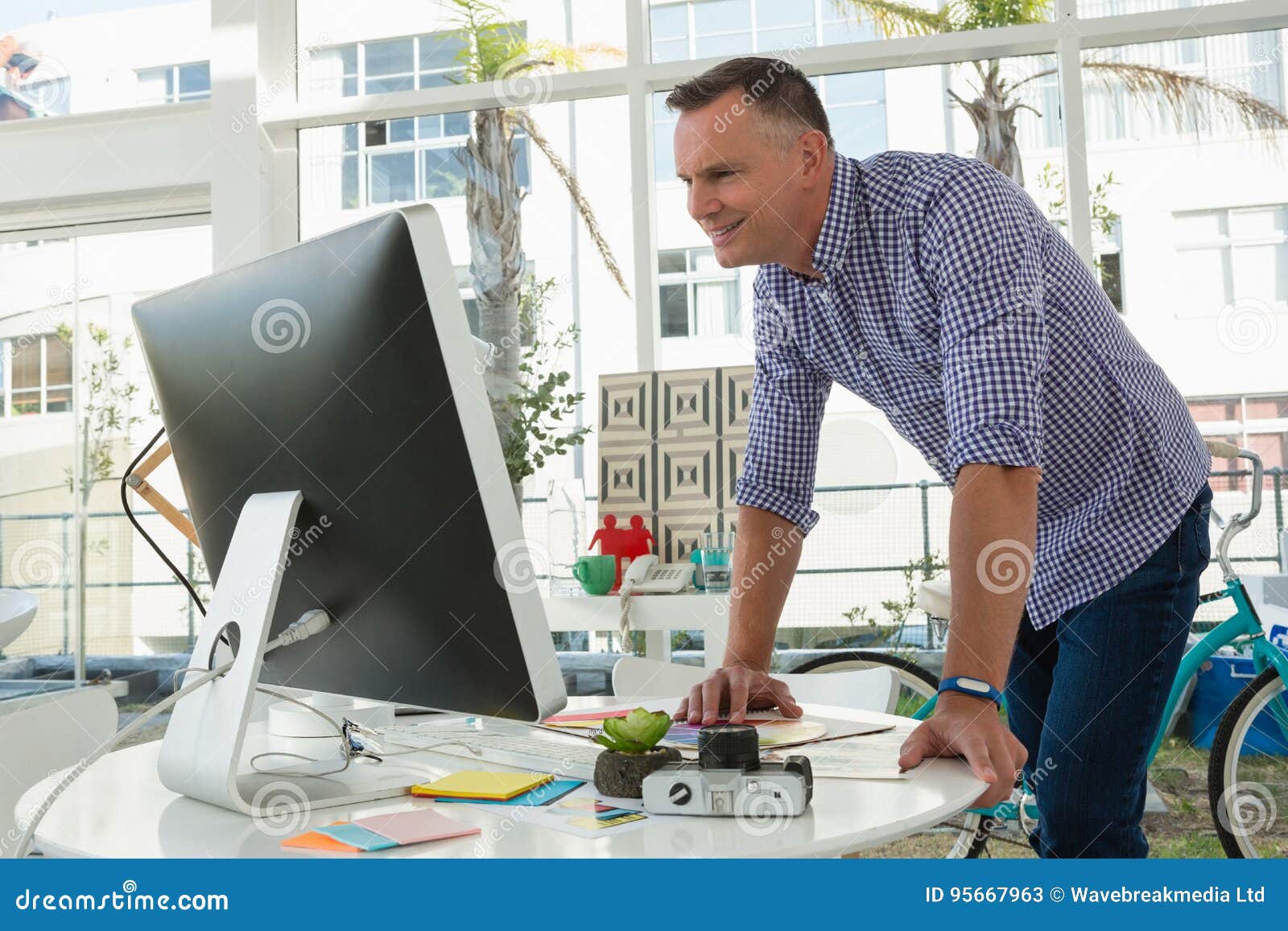 Smiling Designer Using Computer while Standing at Desk Stock Image ...