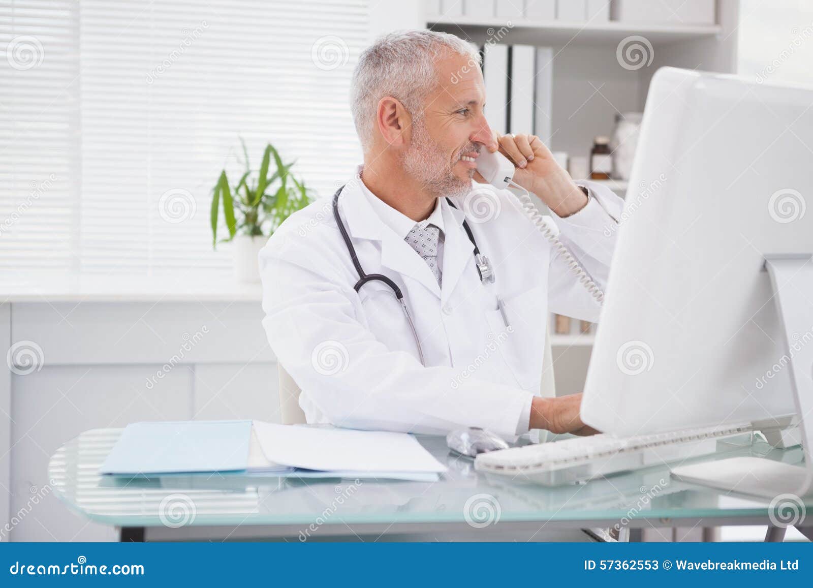 Smiling Doctor Phoning and Using Computer Stock Image - Image of ...