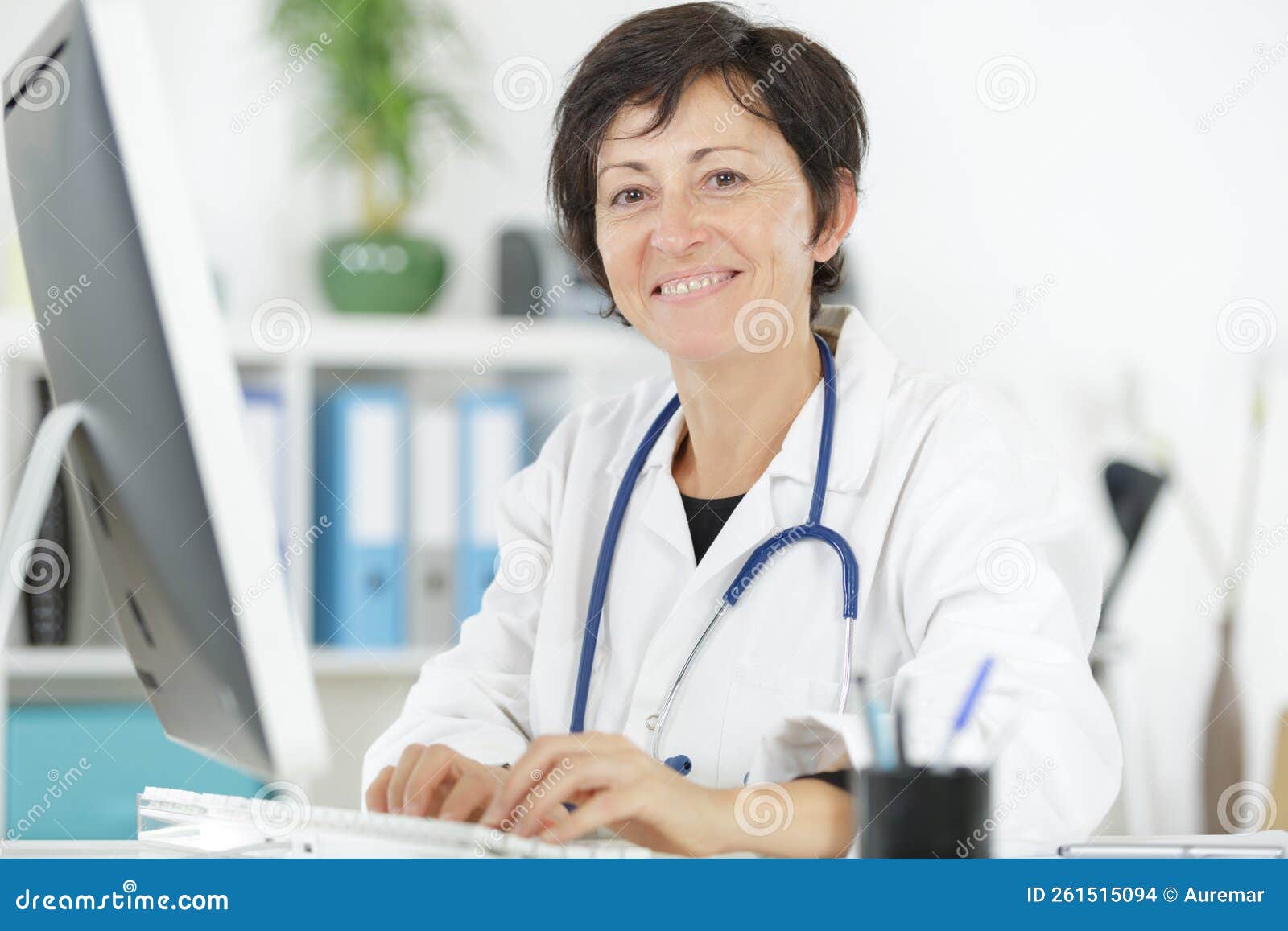 Smiling Doctor Sitting at Desk Stock Photo - Image of doctor ...