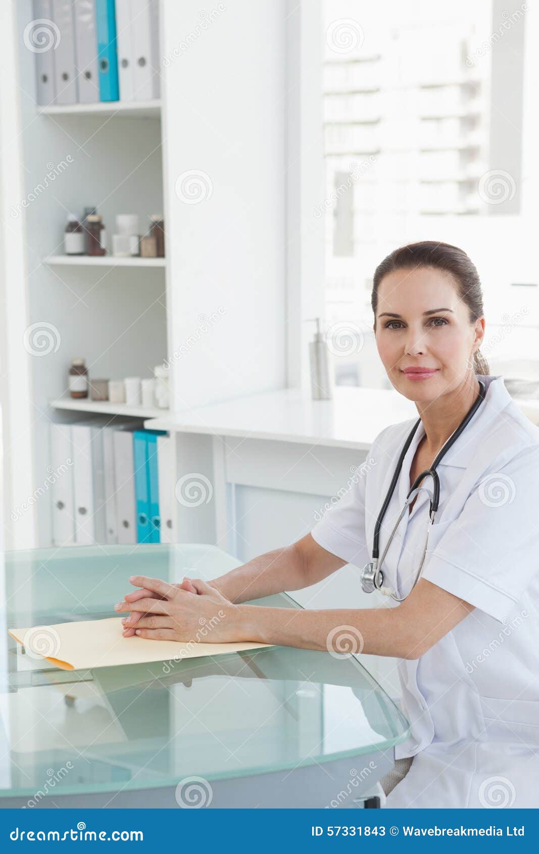 Smiling Doctor Sitting at Her Desk Stock Image - Image of side, coat ...