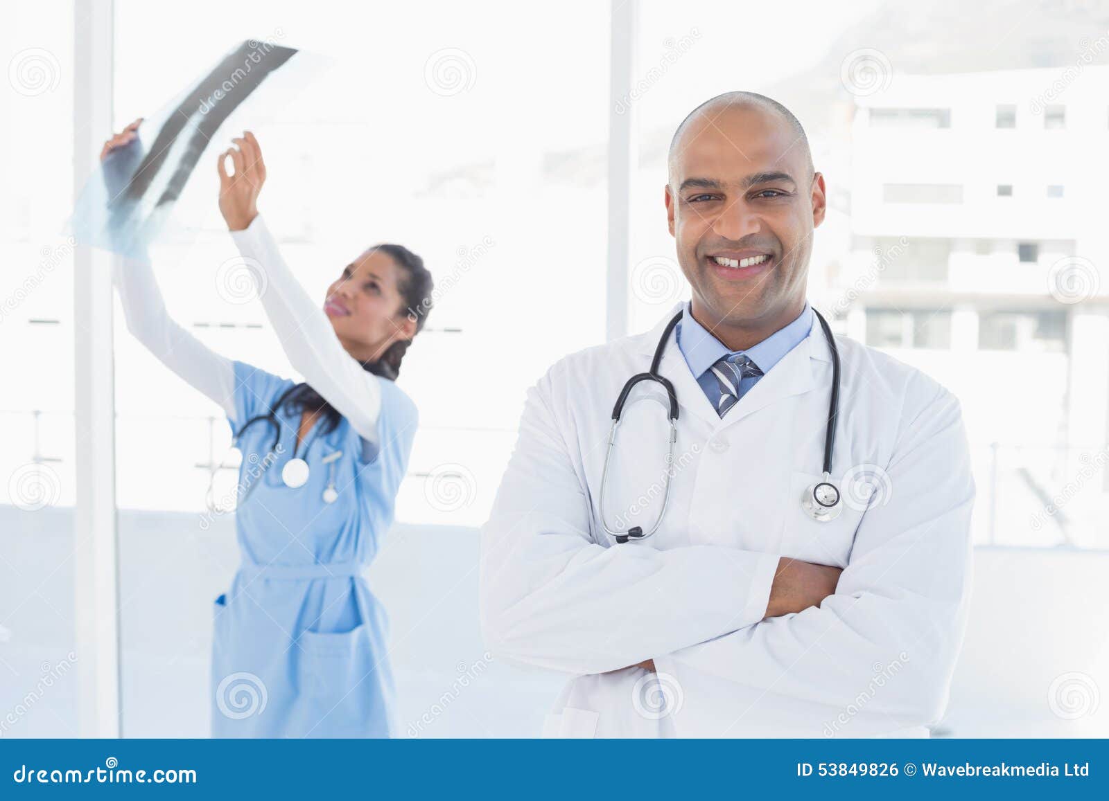 Smiling Doctors Looking at Camera and Analyzing Xray Stock Photo ...