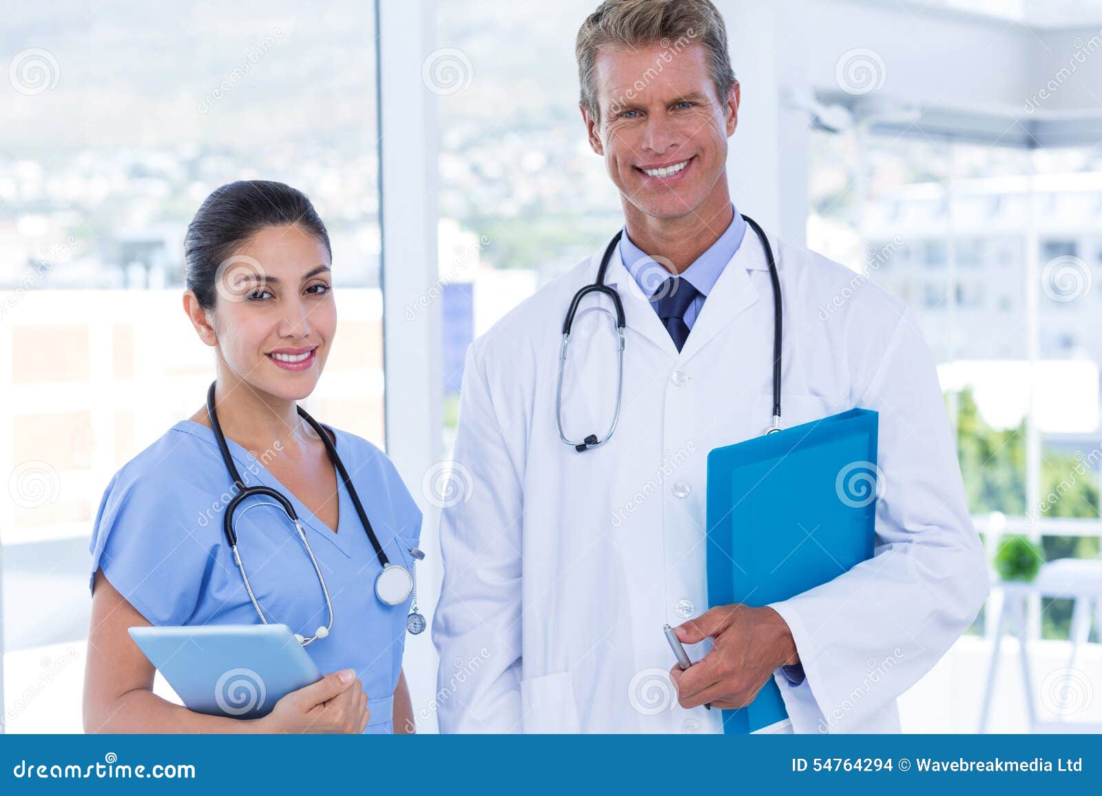 Smiling Doctors Looking at Camera and Holding Clipboards Stock Photo ...