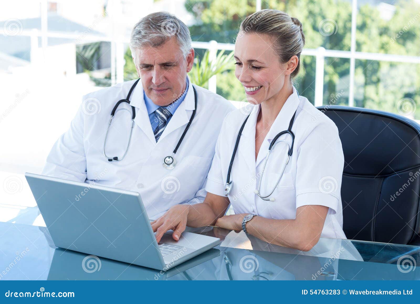 Smiling Doctors Working Together on Laptop Stock Image - Image of ...