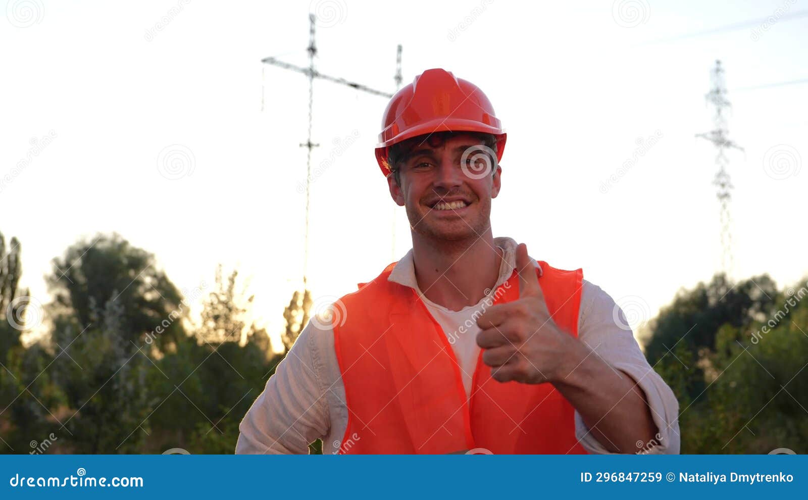 Happy Young Male Engineer Standing Outdoors in Front of a High Voltage ...