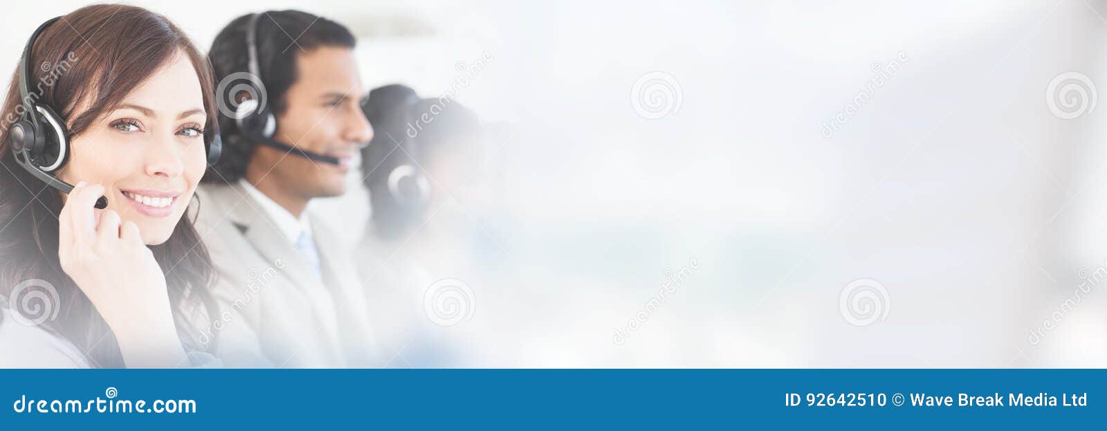 Smiling Employee Working with a Headset while Looking at the Camera ...