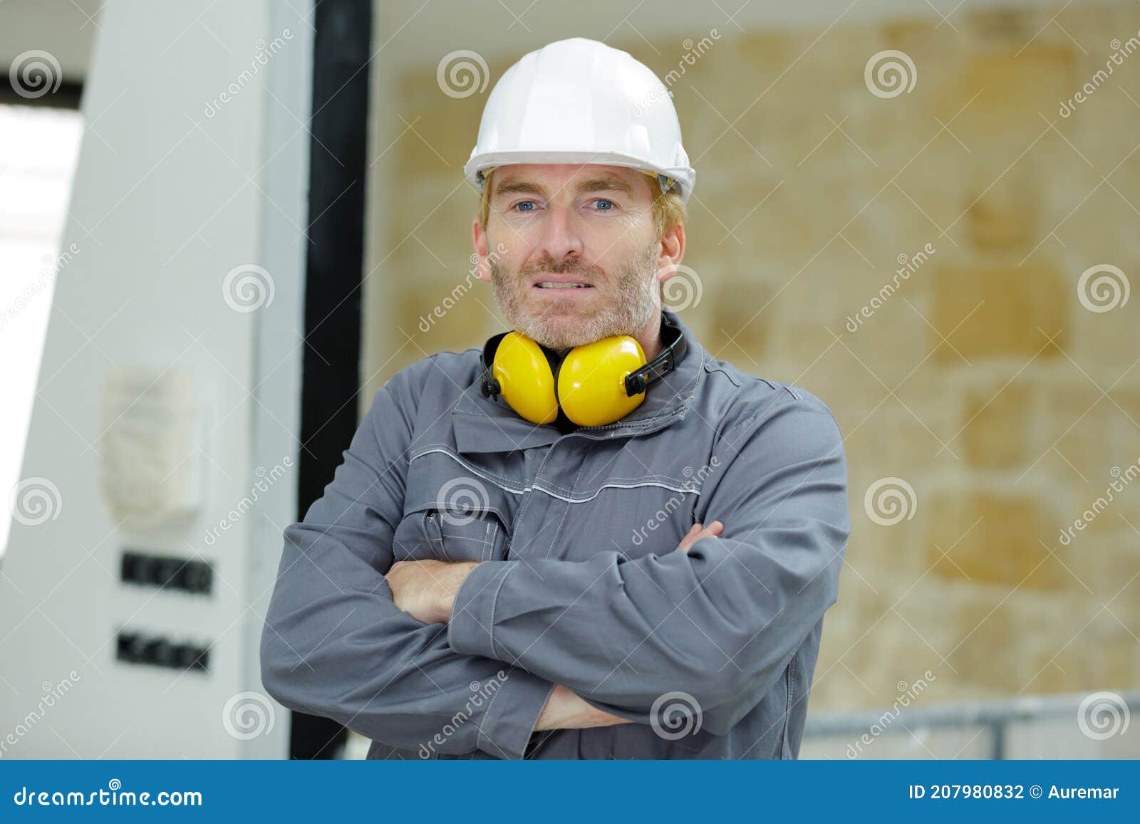 Smiling Engineer Looking at Camera Stock Photo - Image of earmuffs ...