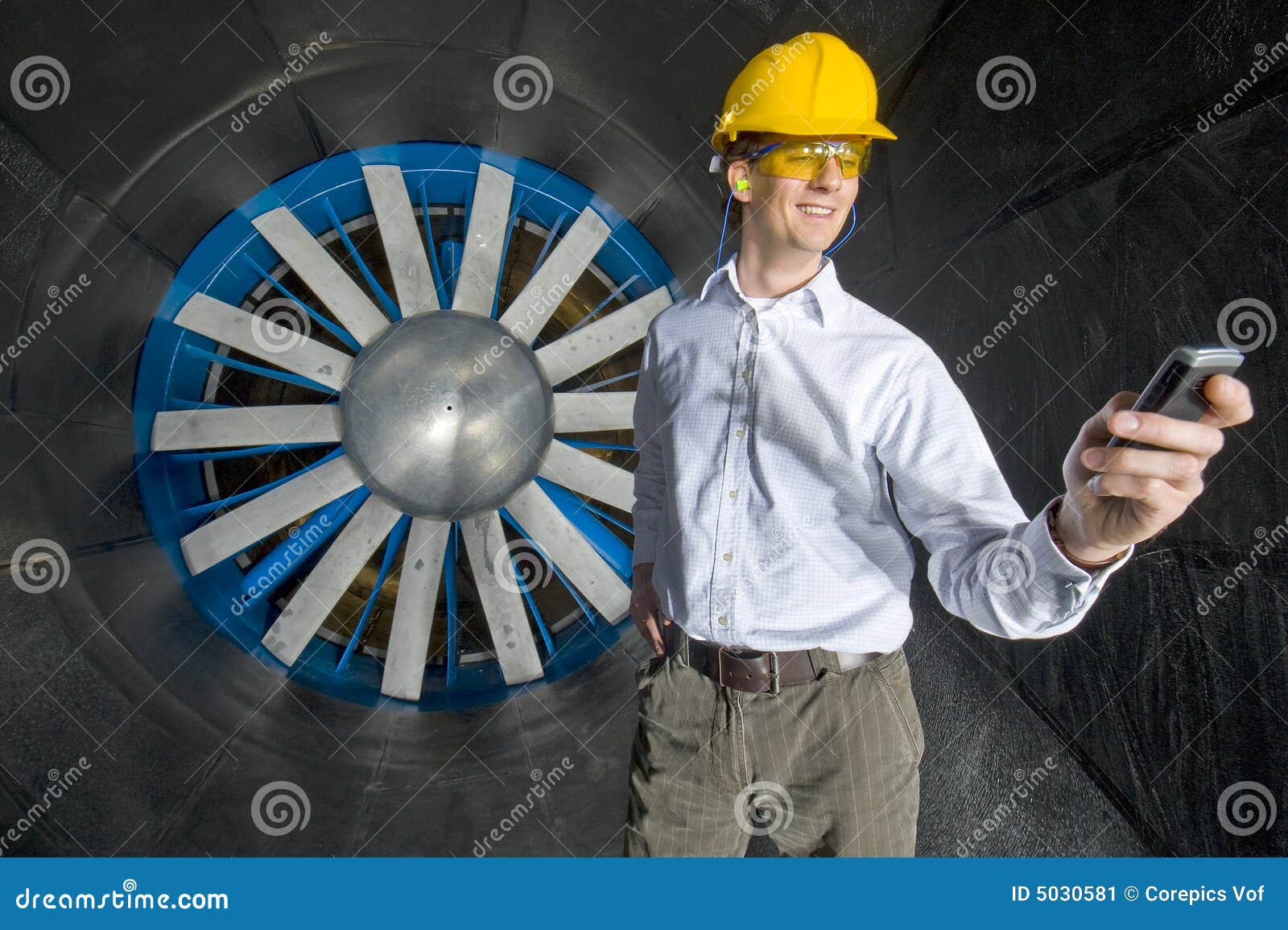 A Smiling Engineer, Looking at His Phone Stock Image - Image of black ...