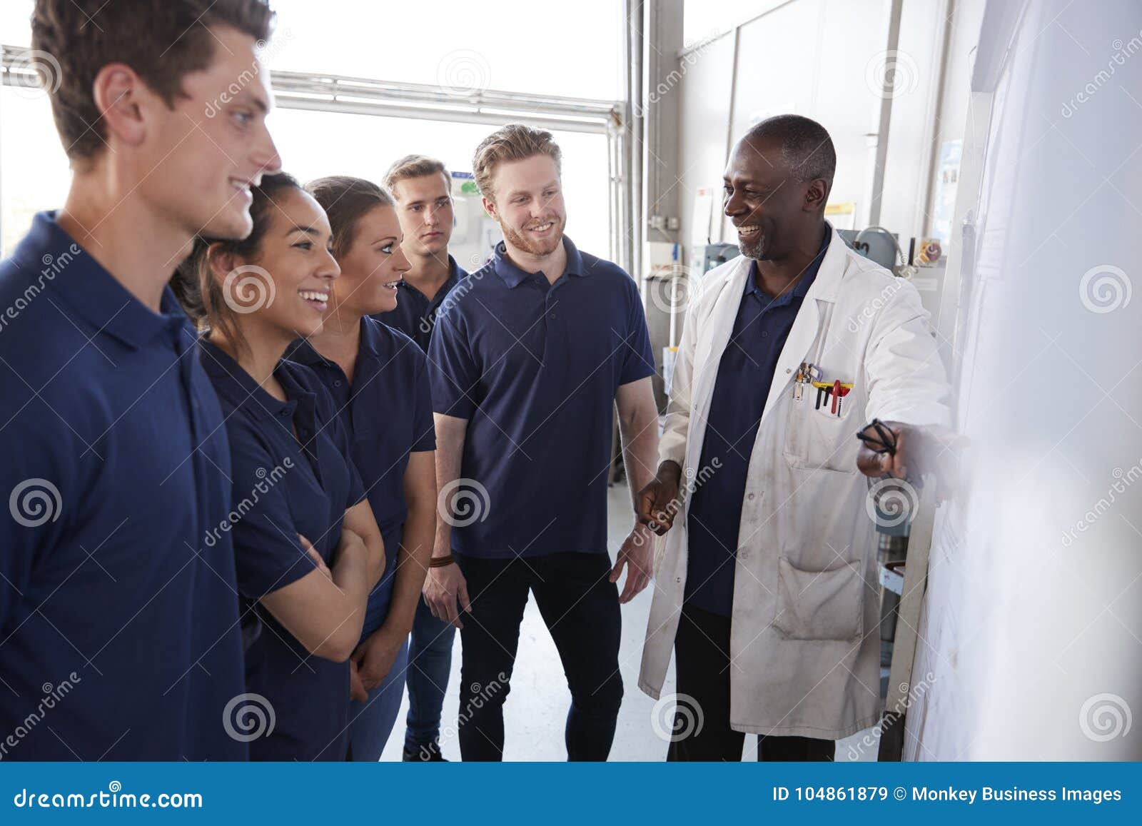 Smiling Engineering Apprentices Gather Round Whiteboard at a Training ...