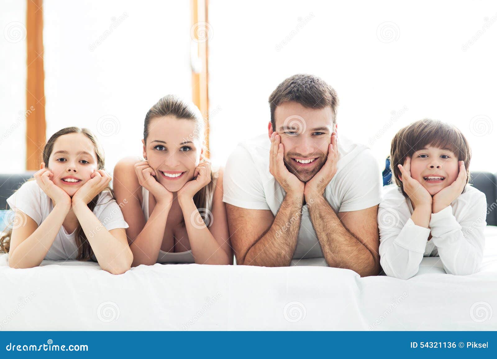 Smiling family in bed stock photo. Image of childhood - 54321136