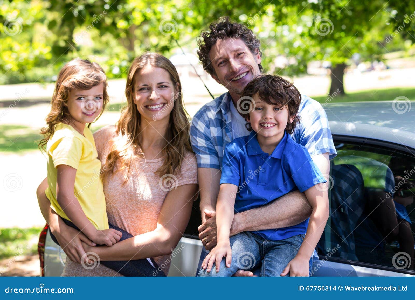 Smiling Family in Front of a Car Stock Photo - Image of enjoyment ...