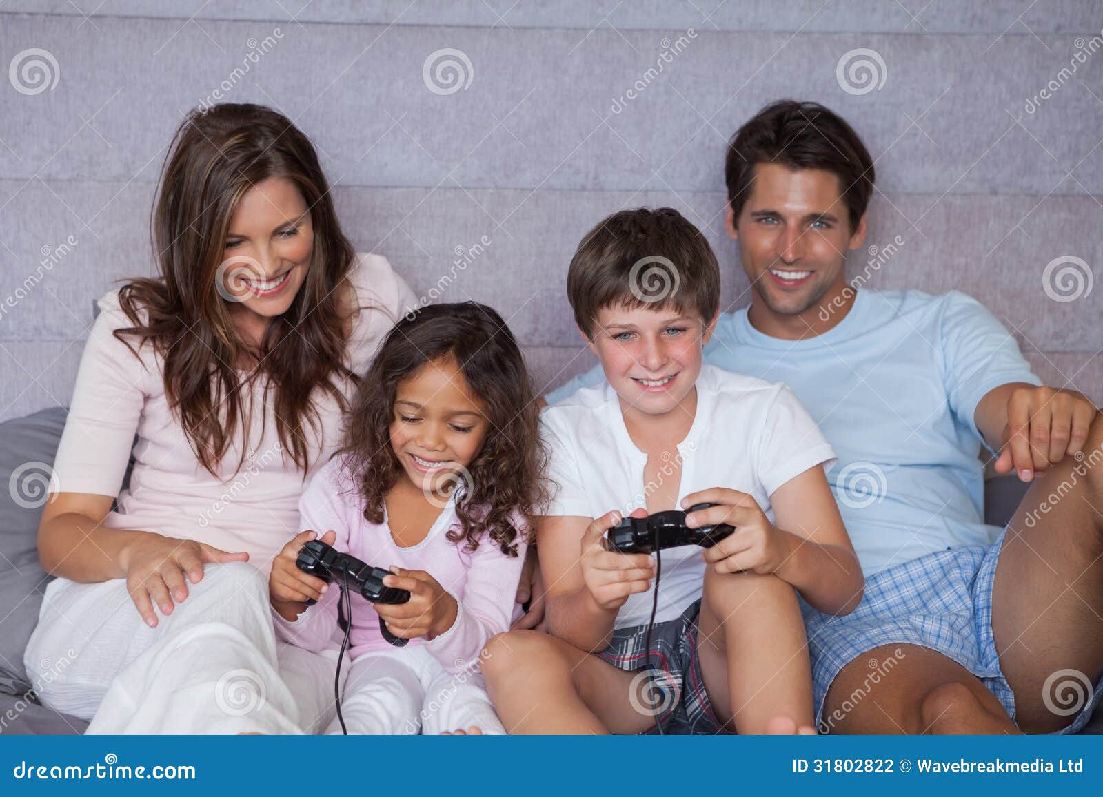Smiling Family Playing Video Games Stock Photo - Image of bedroom ...