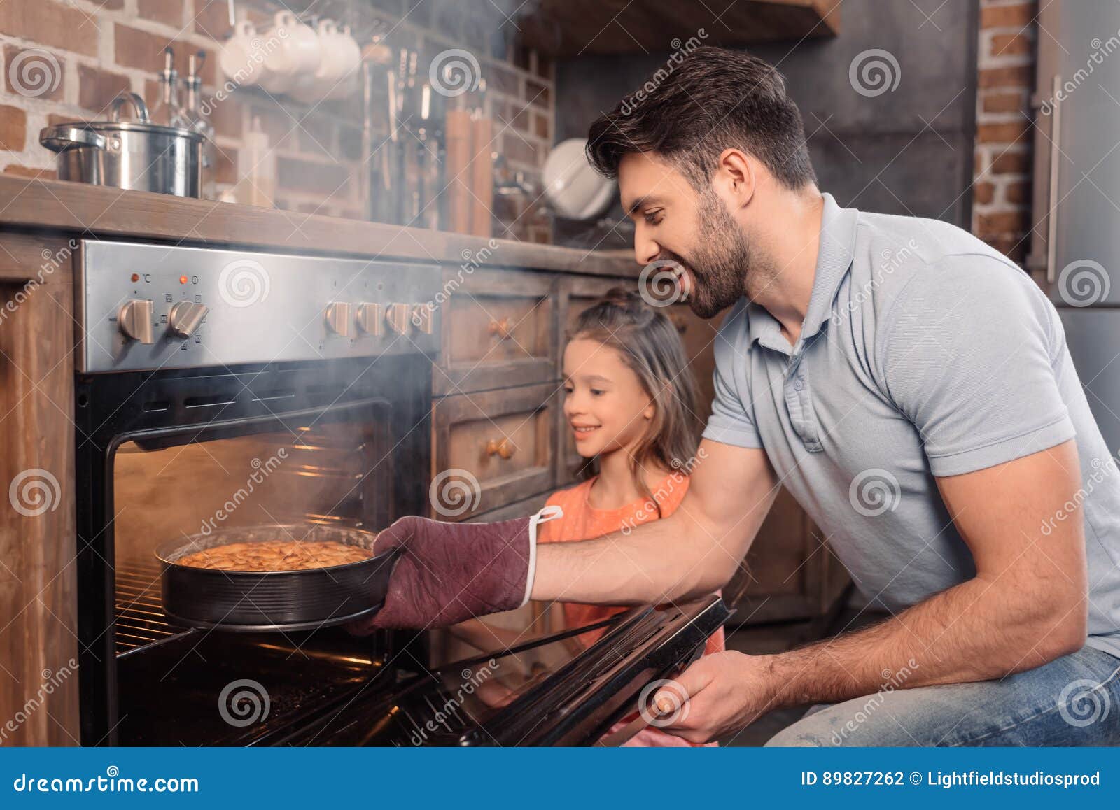Smiling Father and Daughter Taking Cake from Oven Stock Photo - Image ...