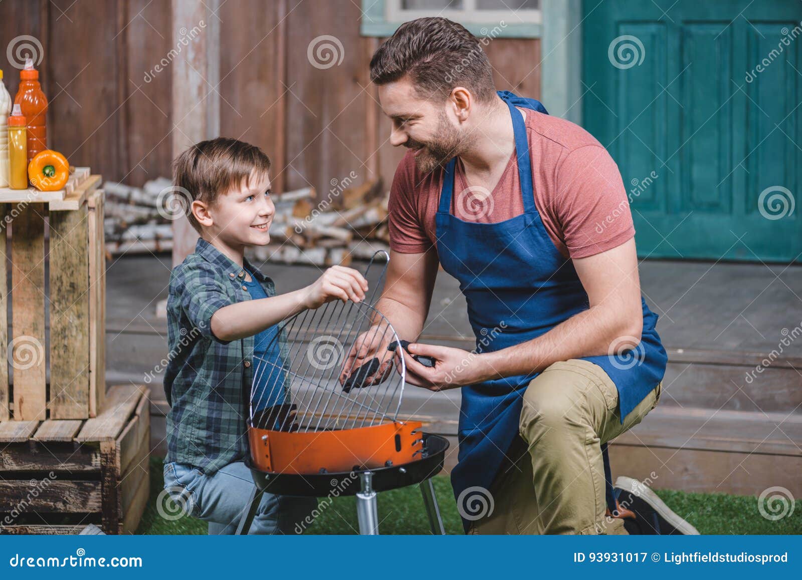 Smiling Father and Son Preparing Grill for Barbecue Stock Image - Image ...