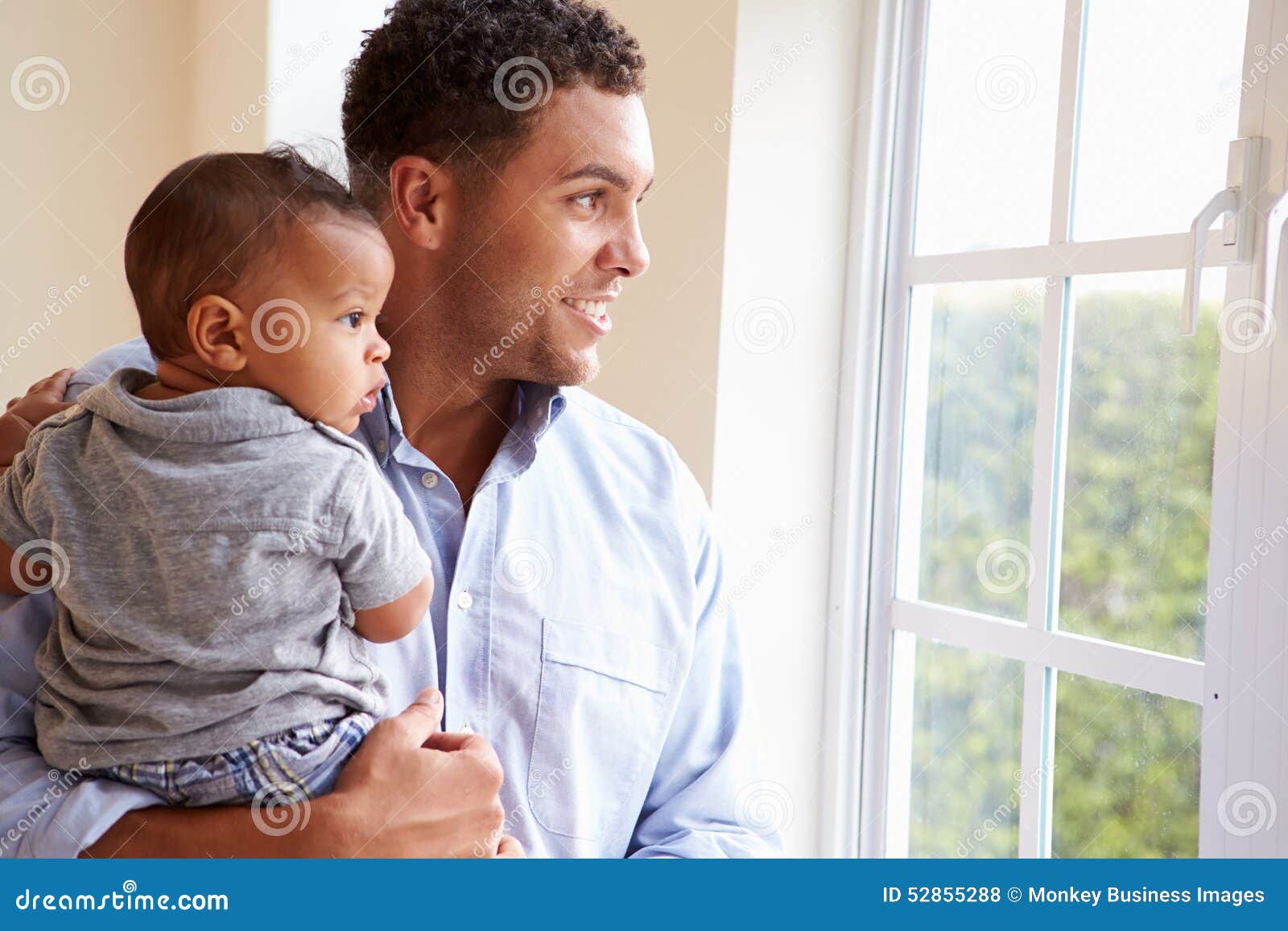 Smiling Father Standing by Window with Baby Son at Home Stock Photo ...