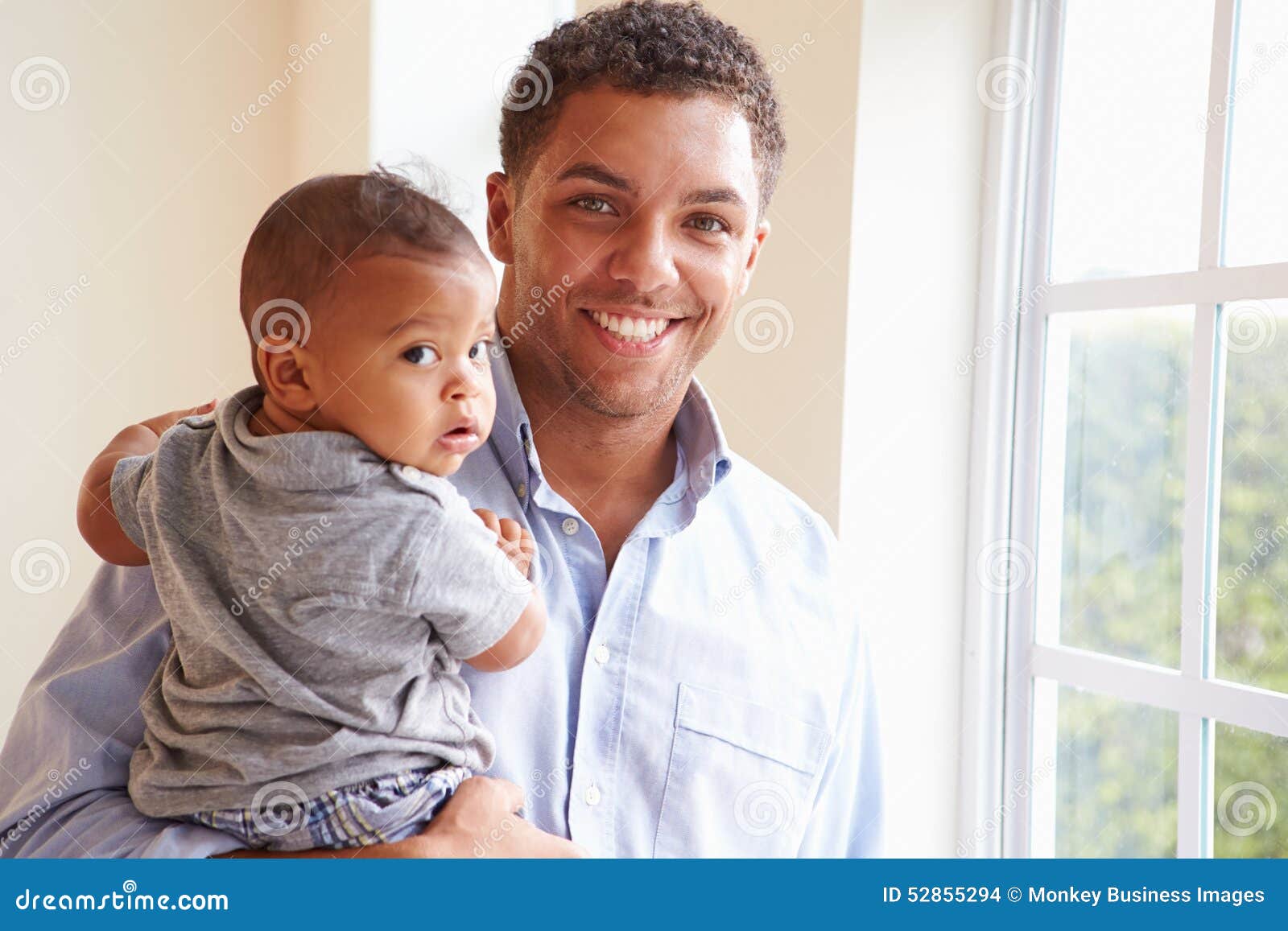 Smiling Father Standing by Window with Baby Son at Home Stock Photo ...