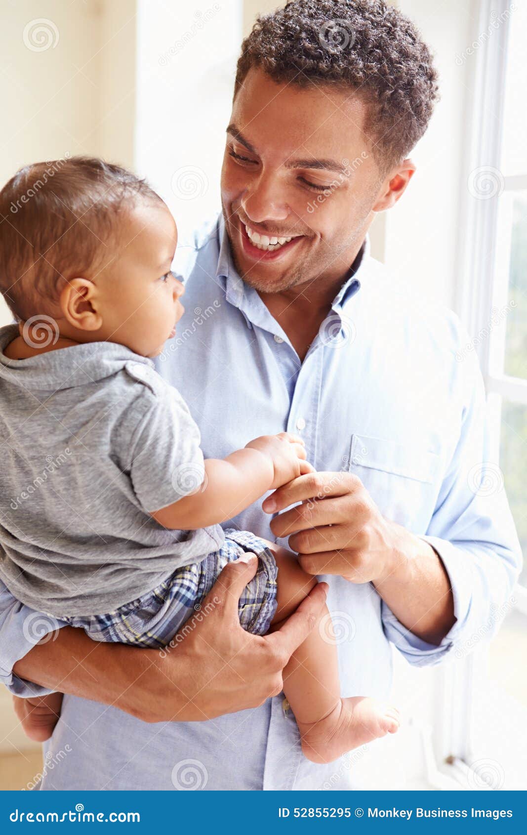 Smiling Father And Young Son Talking Together On Their Sofa Stock ...