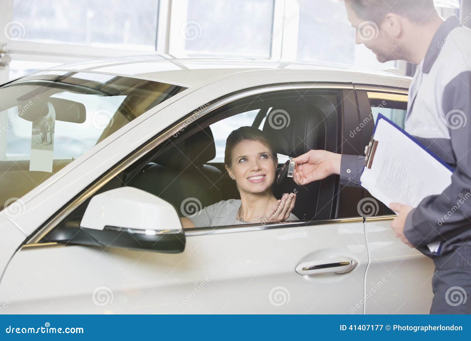 Smiling Female Customer Receiving Car Key from Mechanic in Workshop ...