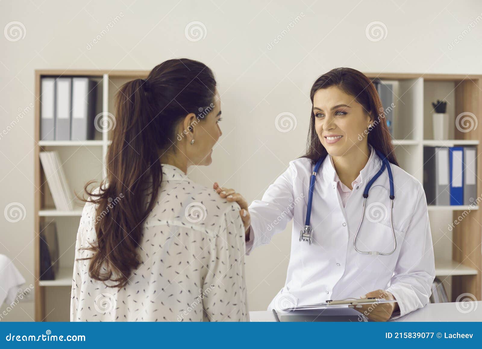 Smiling Female Doctor Placing Hand To Patient Shoulder Show Support To