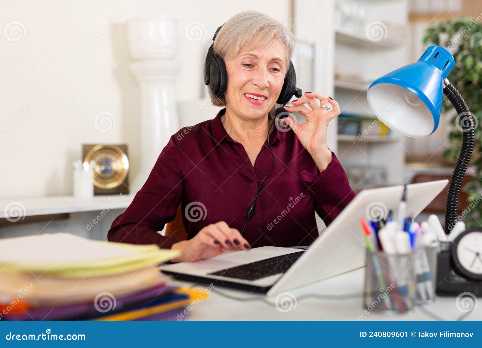 Smiling Female Operator Talking with Customer Using Headset at Office ...
