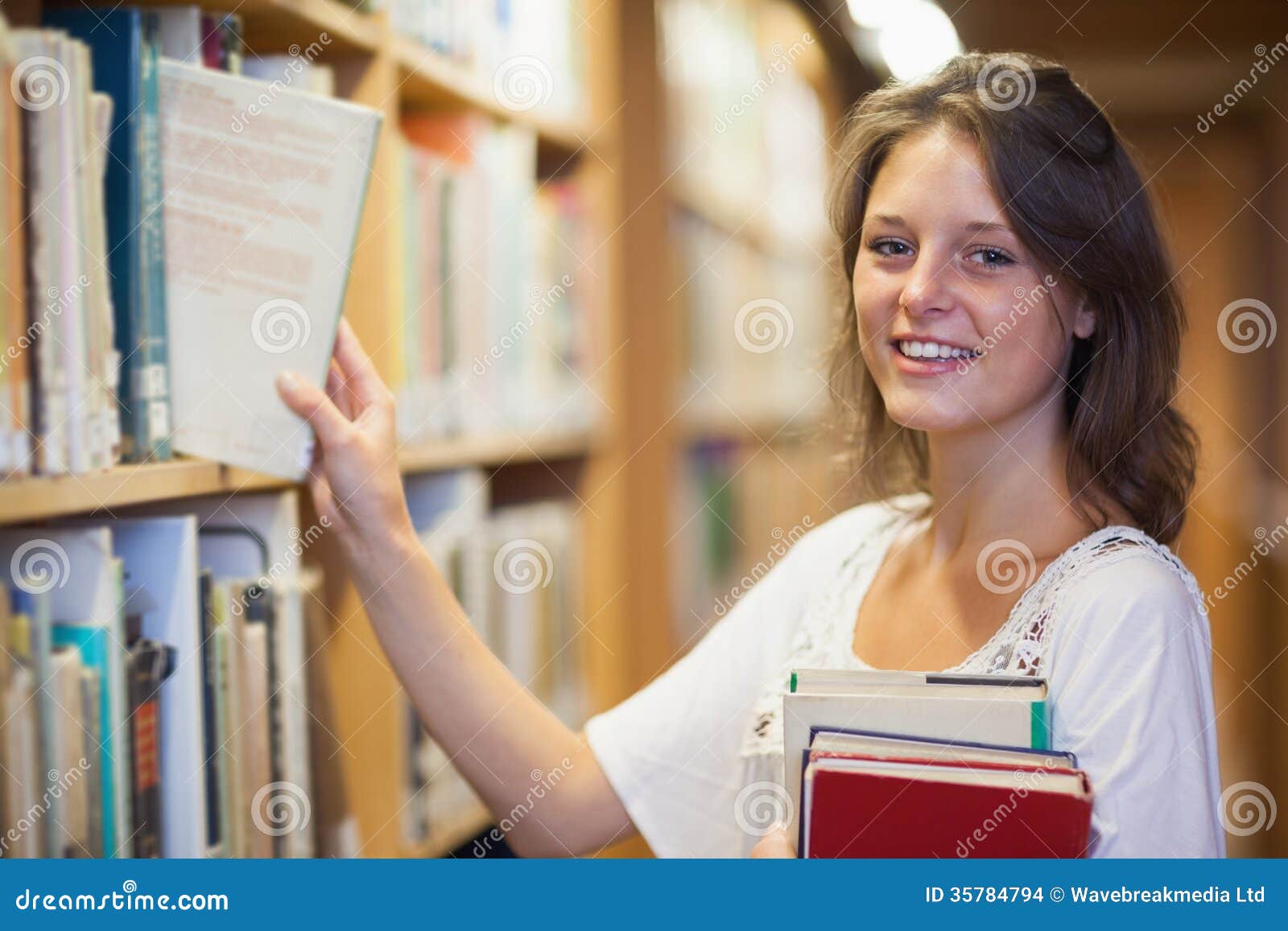 Smiling Female Student Selecting Book in the Library Stock Photo ...