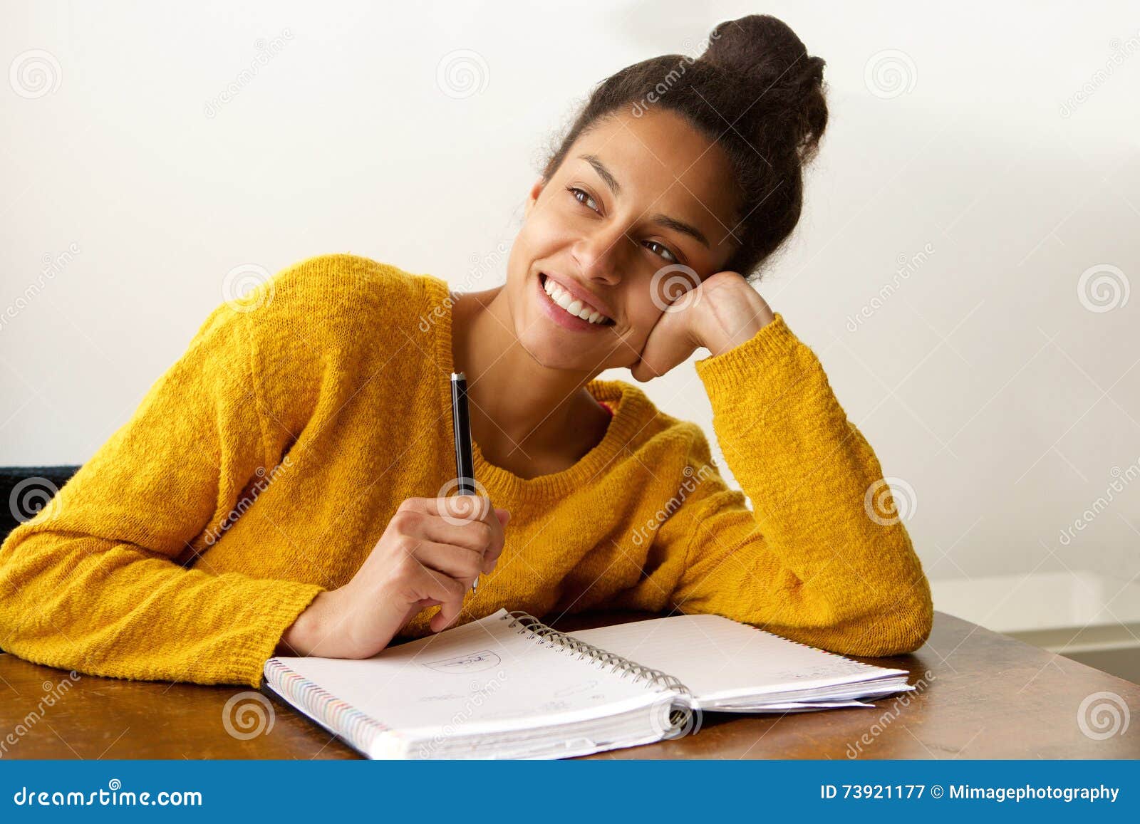 Smiling Female Student Thinking with with Pen and Paper Stock Image ...