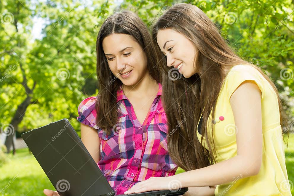 Smiling Female Students Using Laptop Stock Photo - Image of outdoors ...