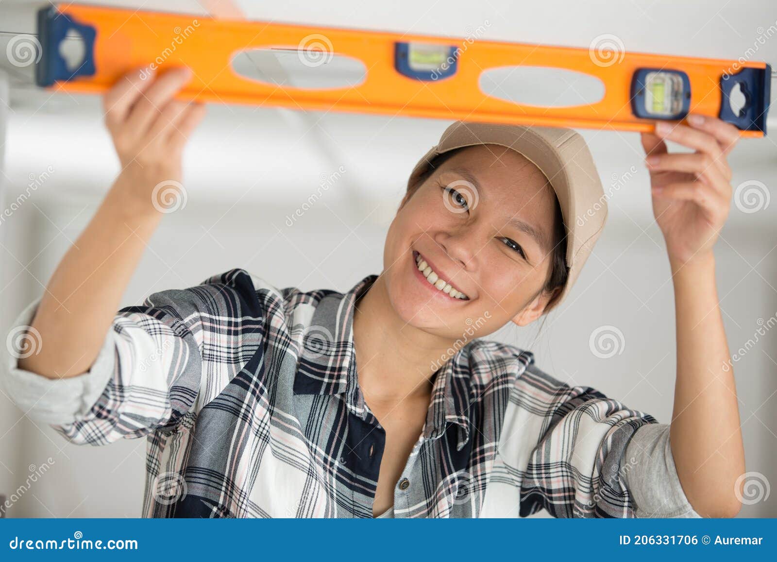 Smiling Female Worker Using Spirit Level Stock Photo - Image of home ...