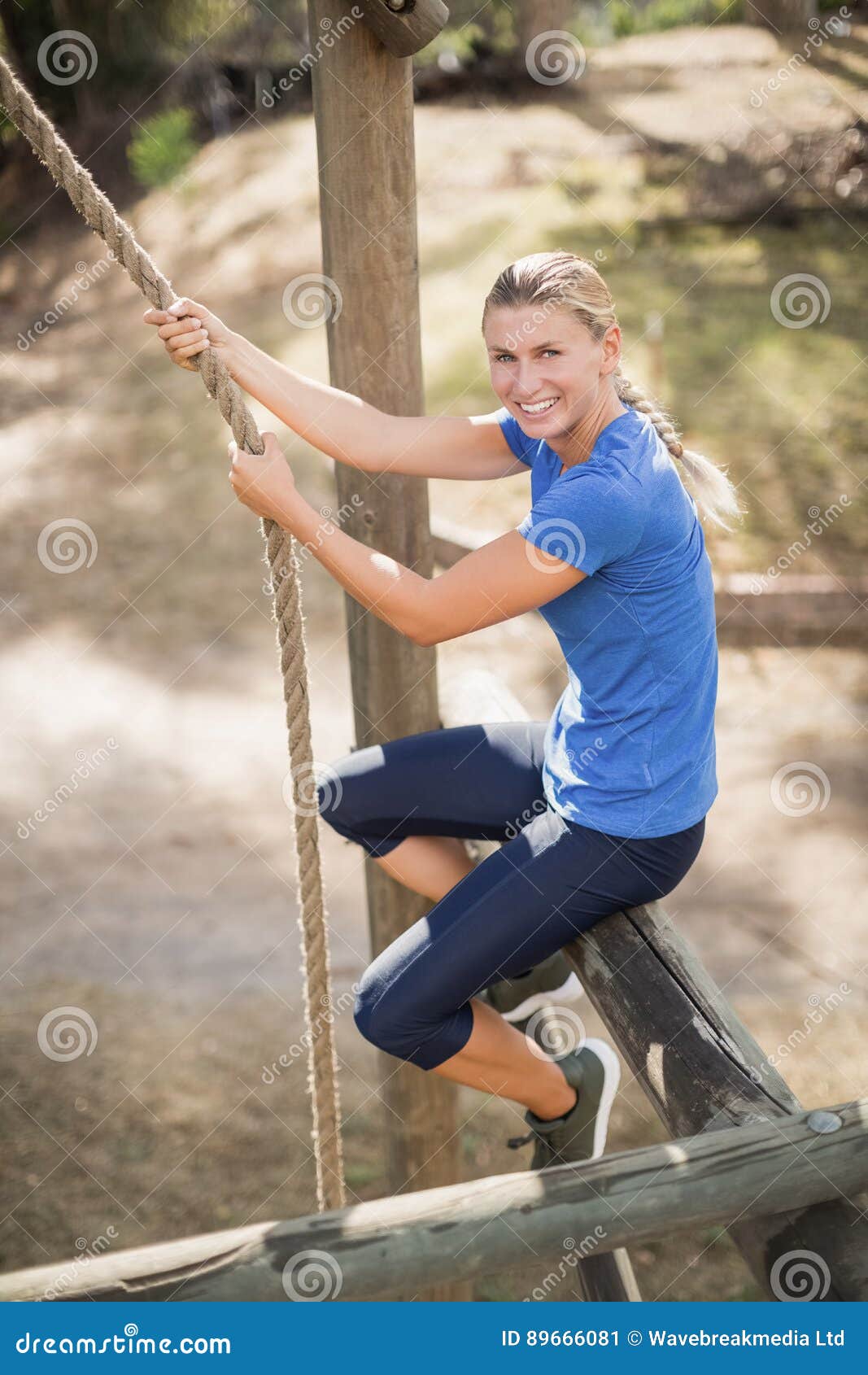 Smiling Fit Woman Climbing Down the Rope during Obstacle Course Stock ...