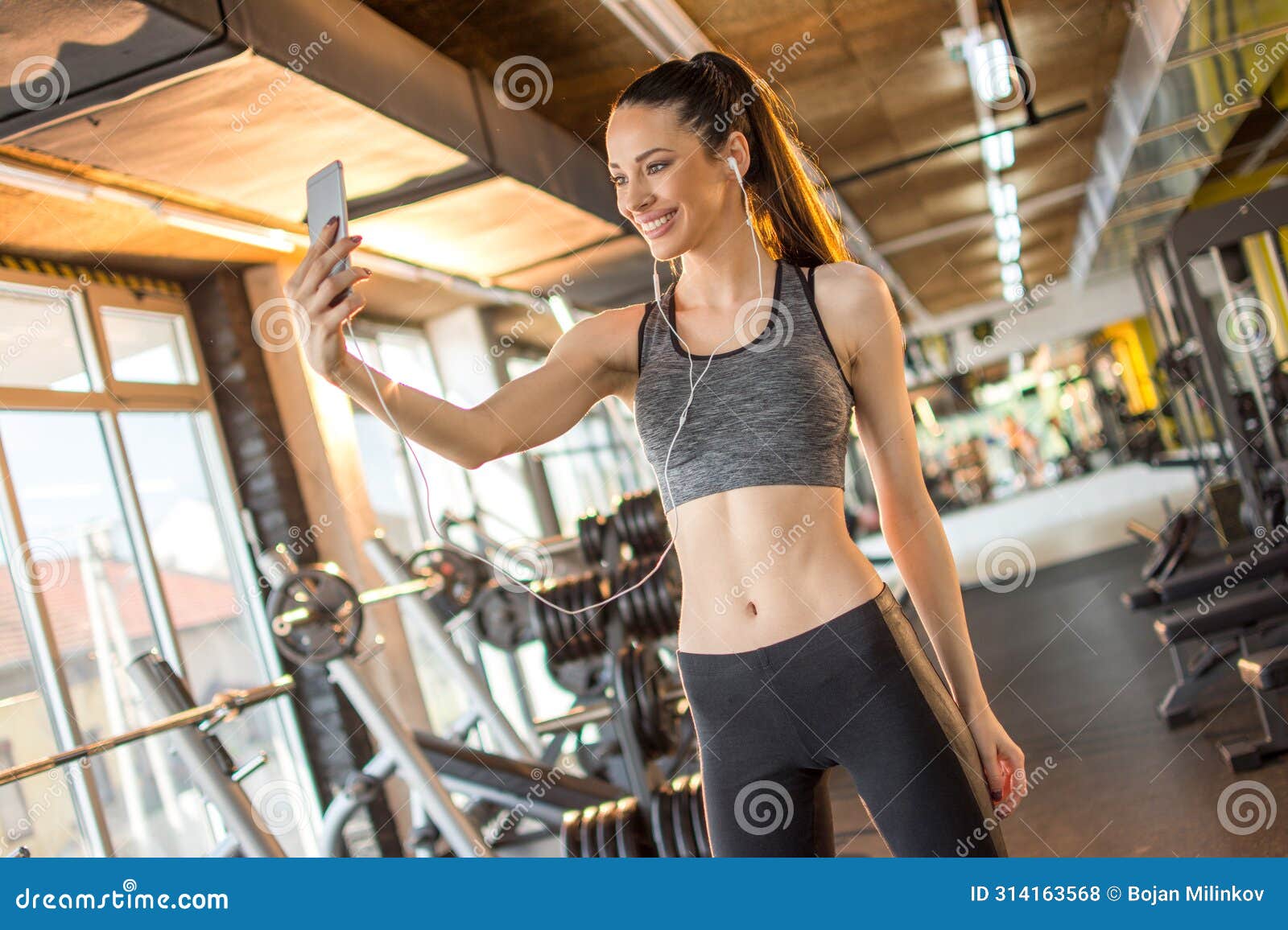 Smiling Fitness Woman Taking Selfies After Training In The Gym Stock