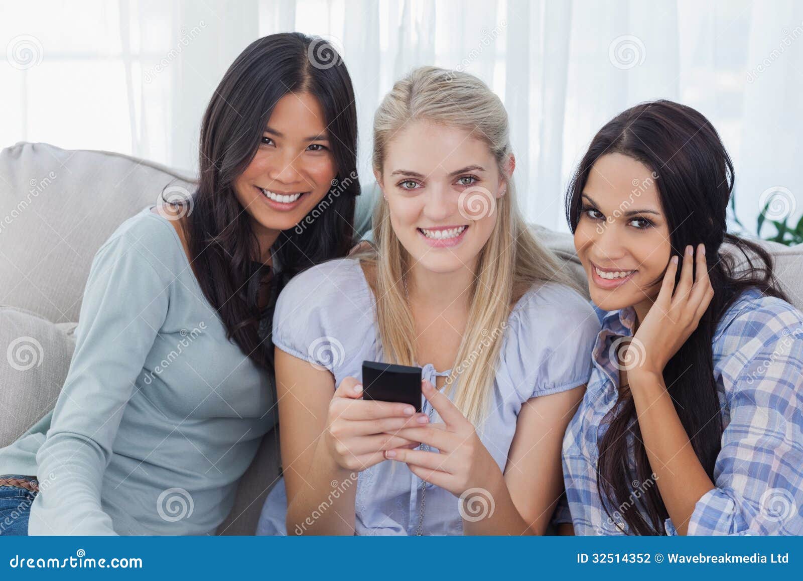 Smiling Friends Holding Smartphone Looking at Camera Stock Photo ...