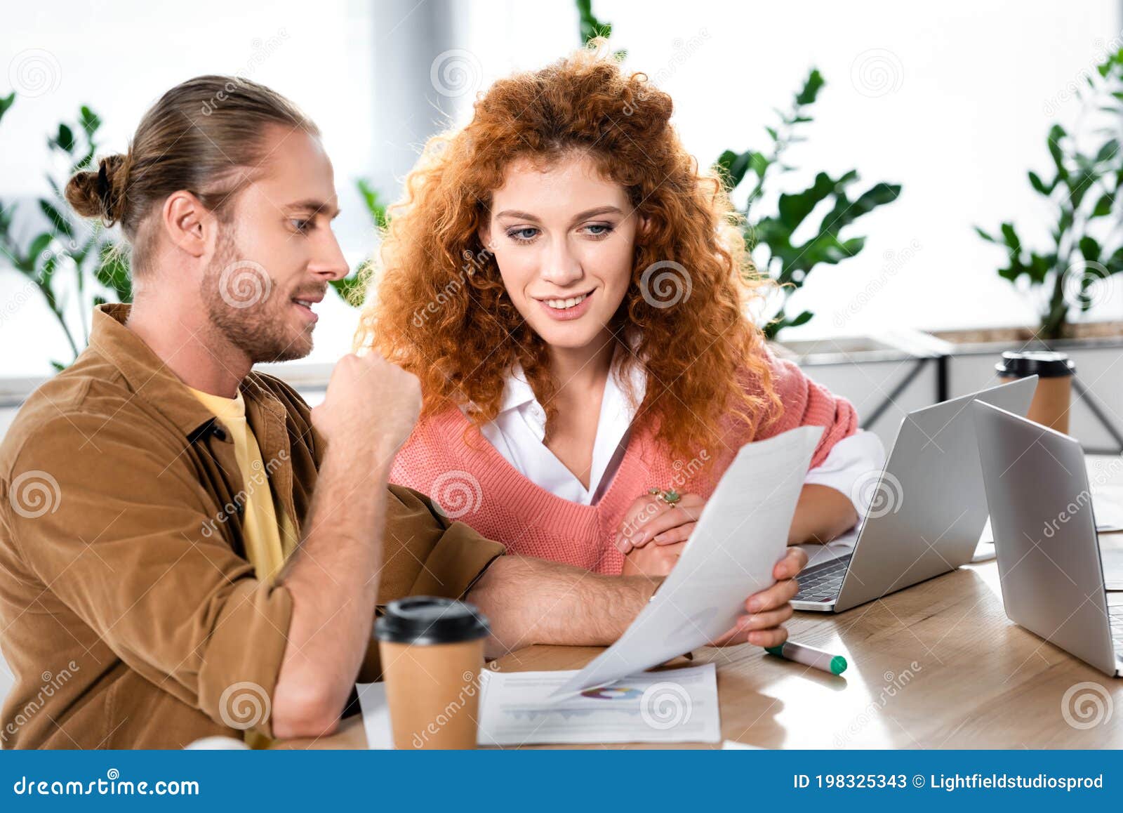 Smiling Friends Sitting at Table and Doing Paperwork in Office Stock ...