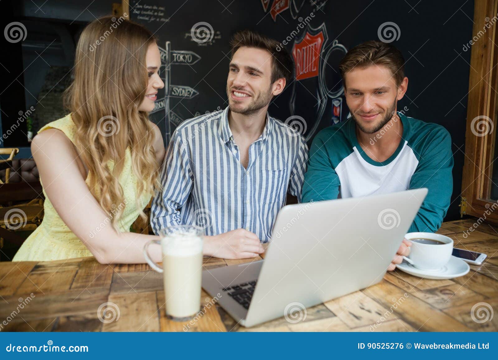 Smiling Friends Using Laptop while Sitting at Table Stock Photo - Image ...