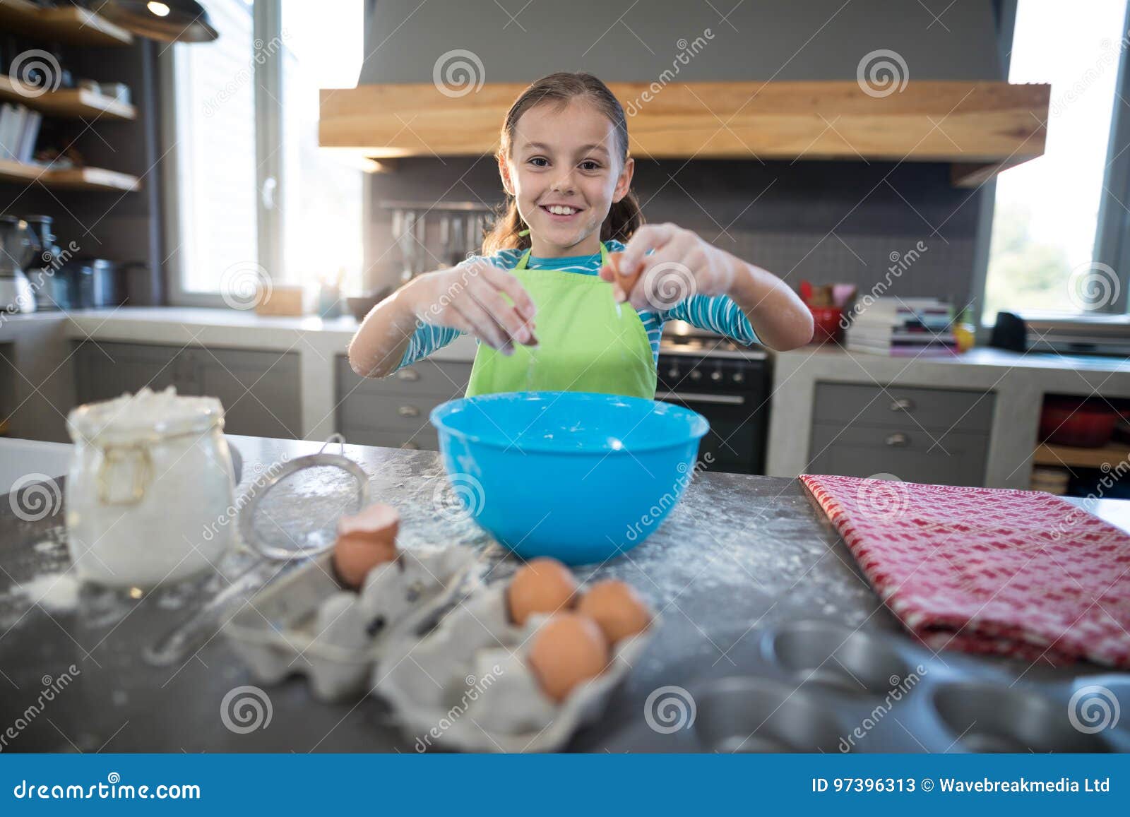 Smiling girl breaking egg stock image. Image of apron - 97396313