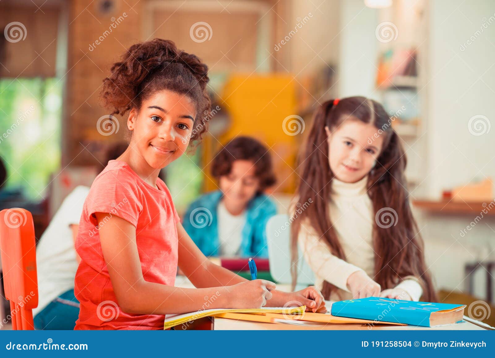 Smiling Girl Doing Her Homework Together with Her Classmate Stock Photo ...