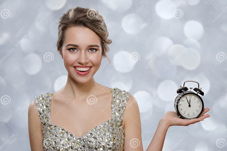 Smiling Girl In A Shiny Dress Shows The Time On The Clock Five Minutes Before The Start Of The